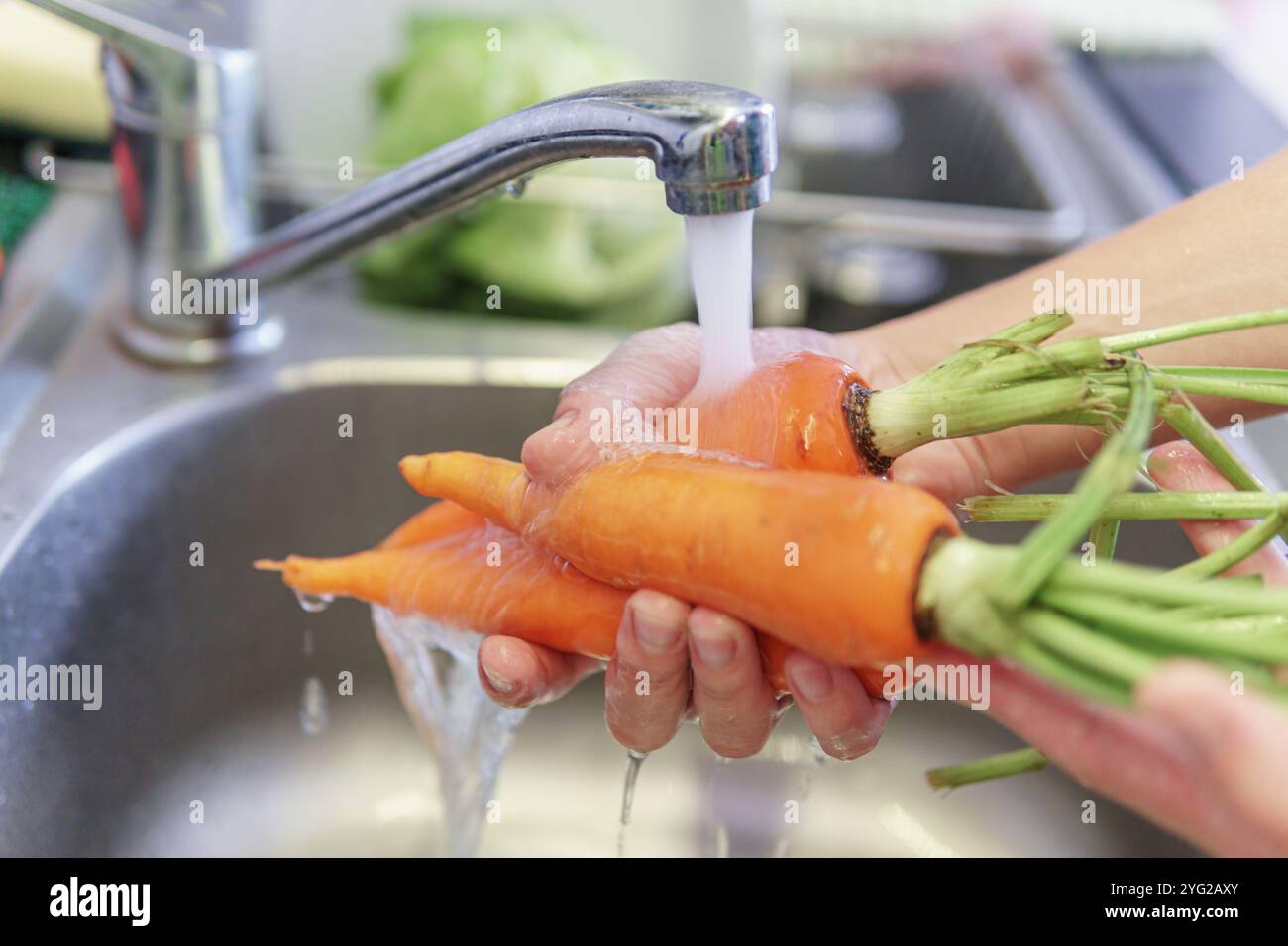 Woman cleaning carrots kitchen hi-res stock photography and images - Alamy
