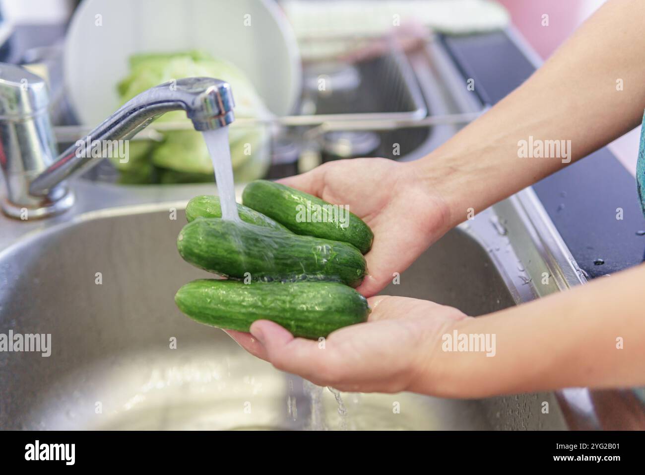 Hands washing cucumbers hi-res stock photography and images - Alamy