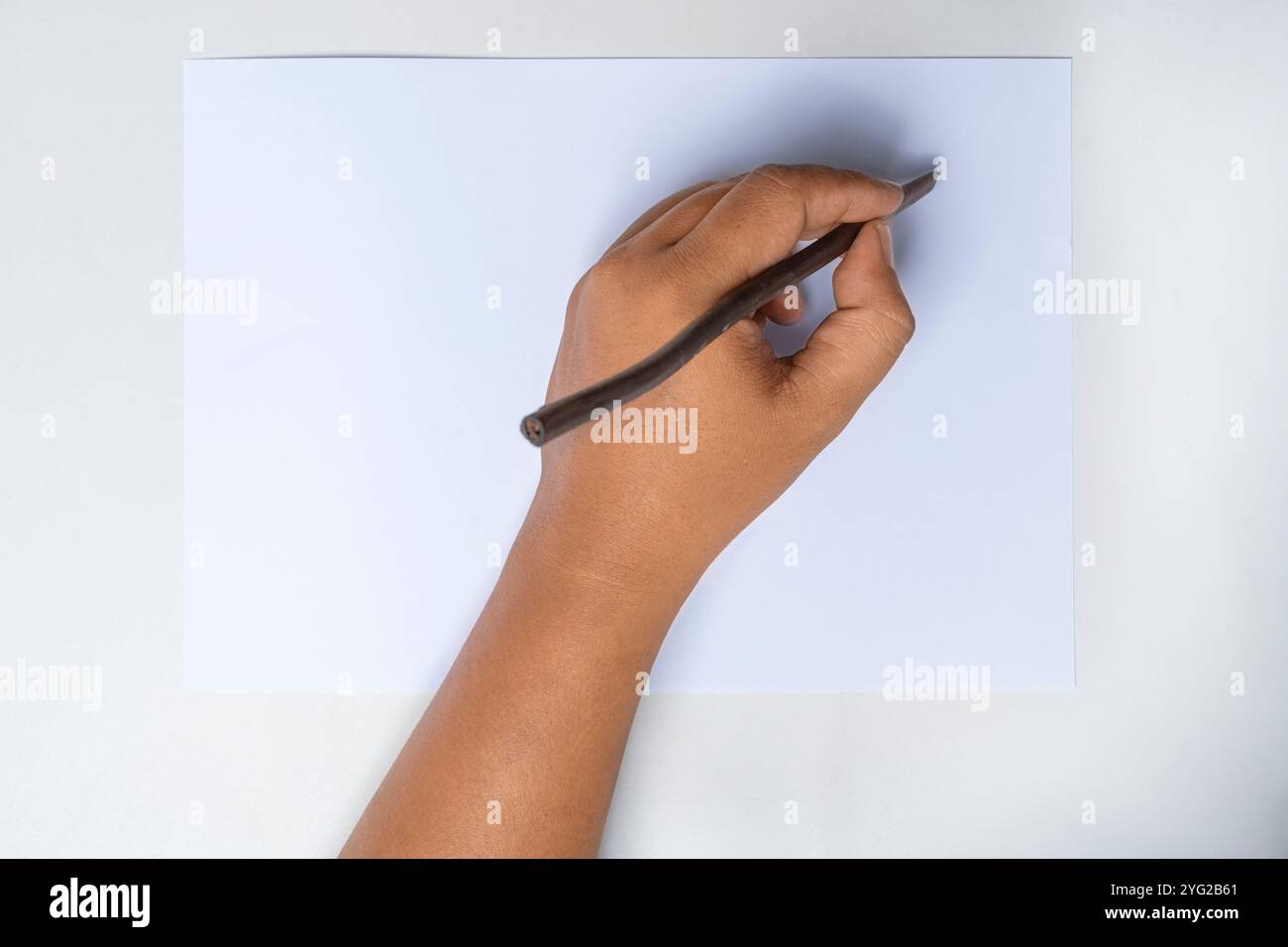 Human hand writing using calligraphy reeds on white paper. Mockup. Copy ...