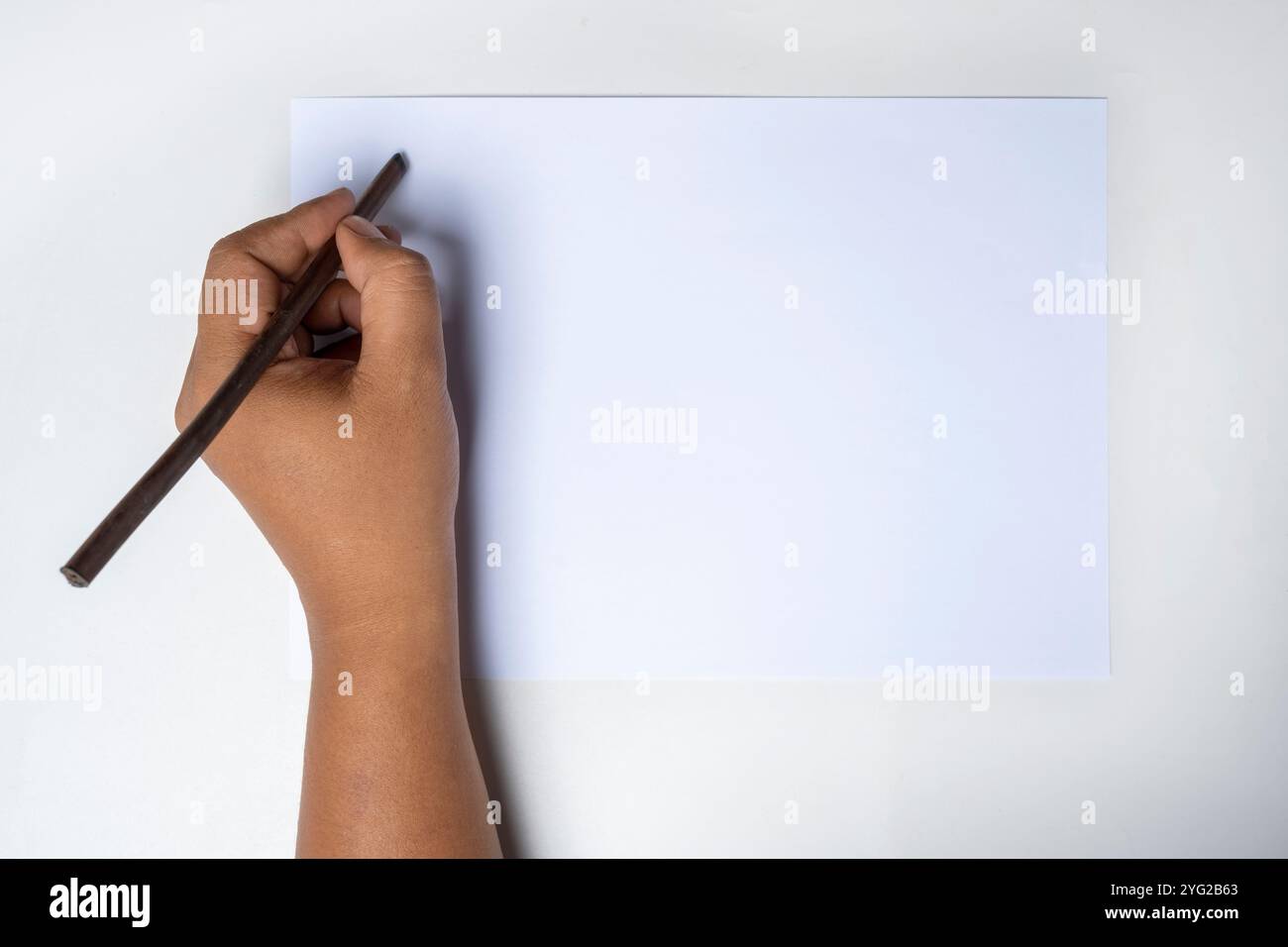 Human hand writing using calligraphy reeds on white paper. Mockup. Copy ...