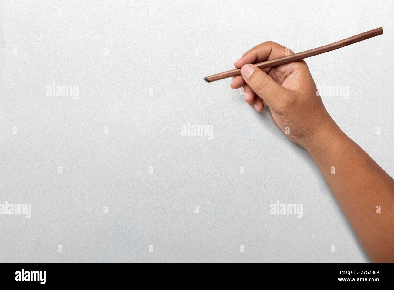Human hand writing using calligraphy reeds on white paper. Mockup. Copy ...