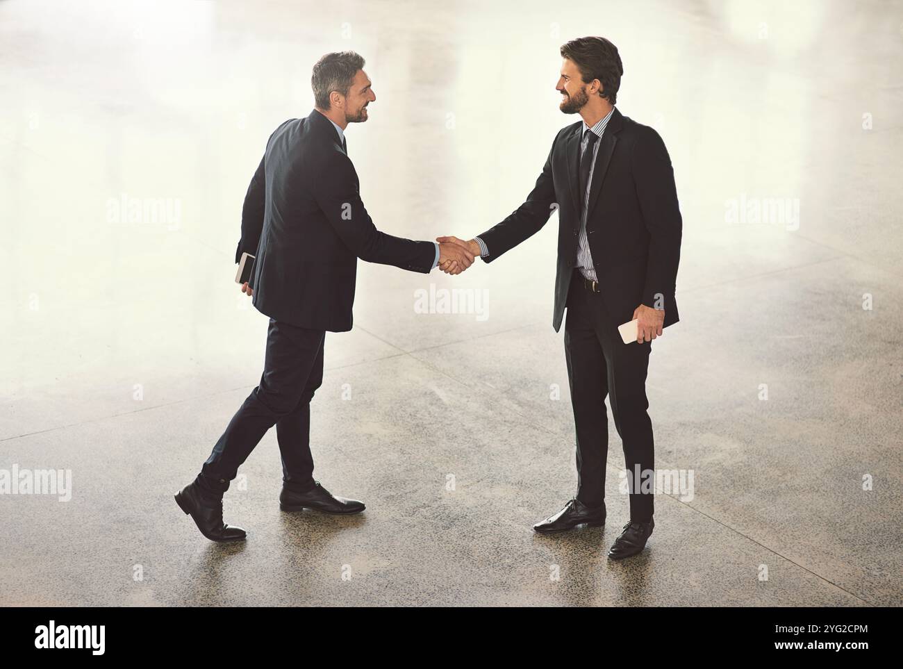 Above, thank you and men in lobby, handshake and partnership with ...