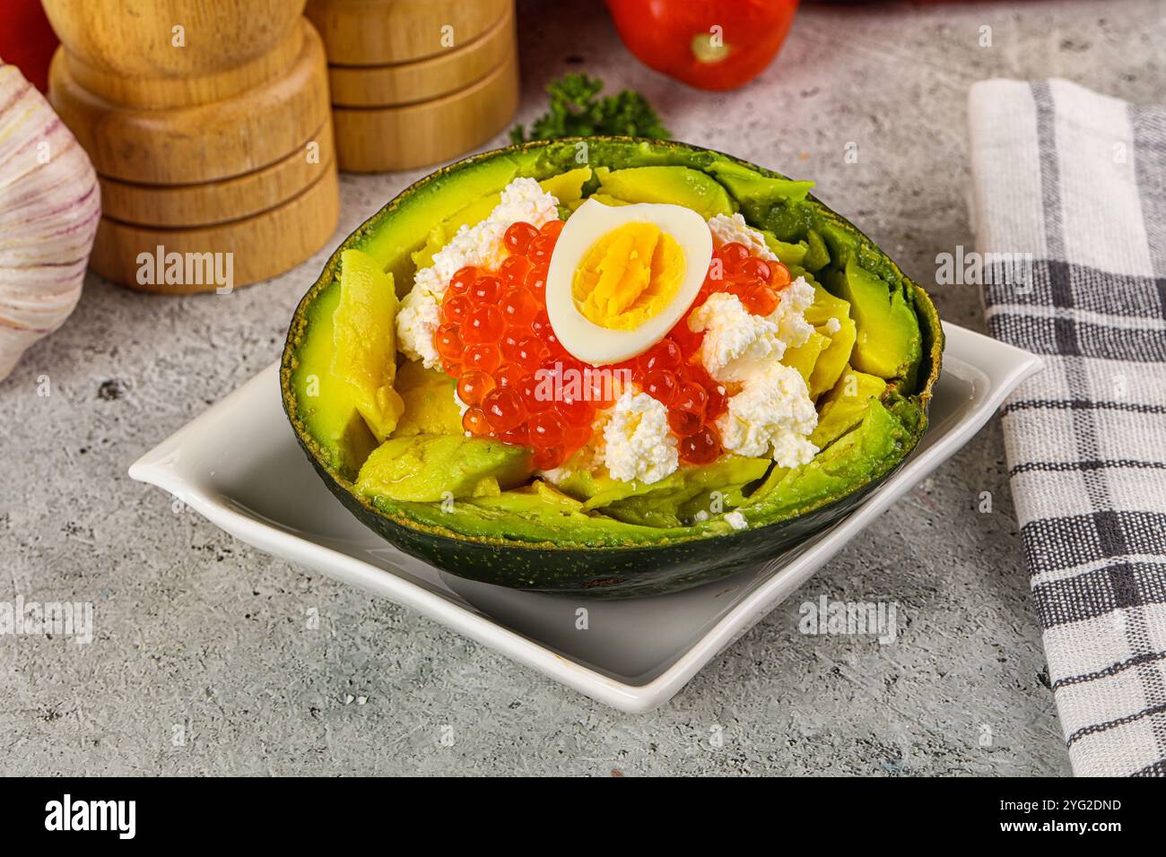 Avocado with red caviar and quil egg and soft cheese Stock Photo - Alamy