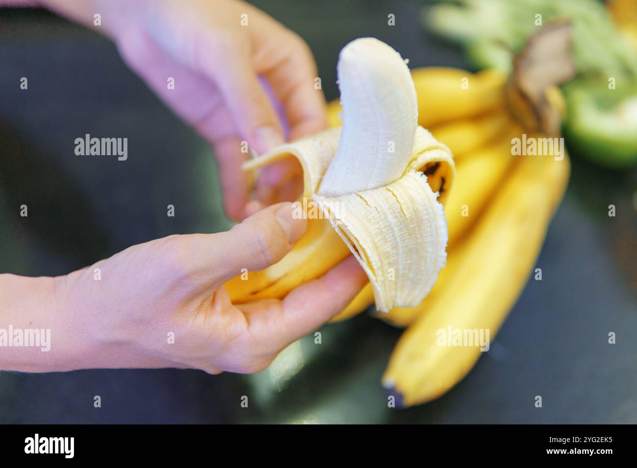 Woman hands peeling fresh banana in a kitchen. Ripe fruit Stock Photo ...