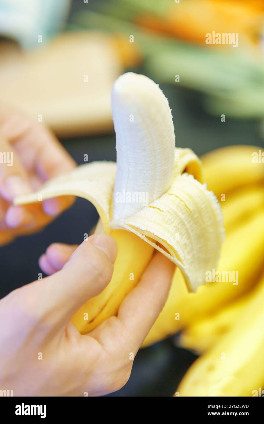 Woman hands peeling fresh banana in a kitchen. Ripe fruit Stock Photo ...