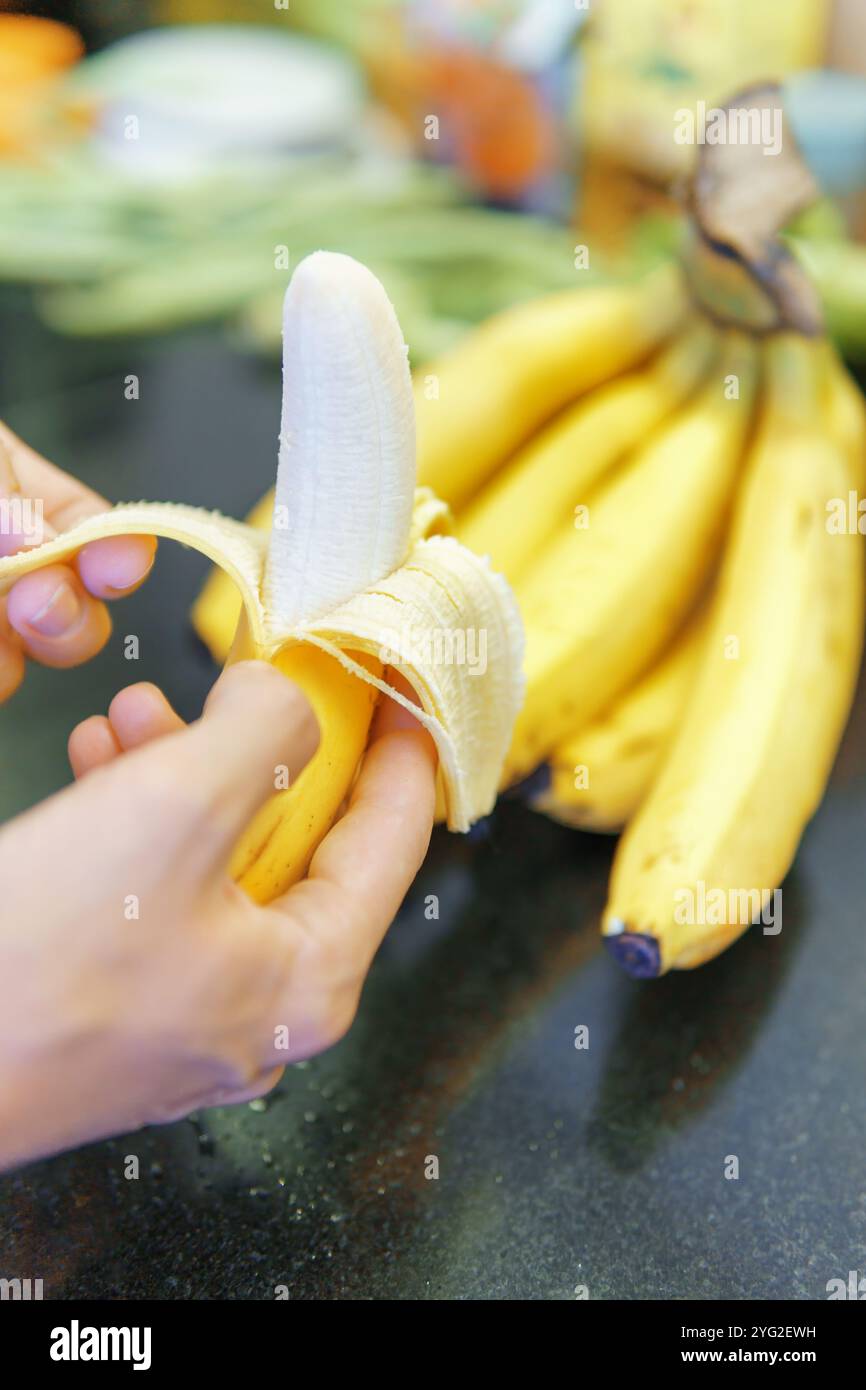 Woman hands peeling fresh banana in a kitchen. Ripe fruit Stock Photo ...