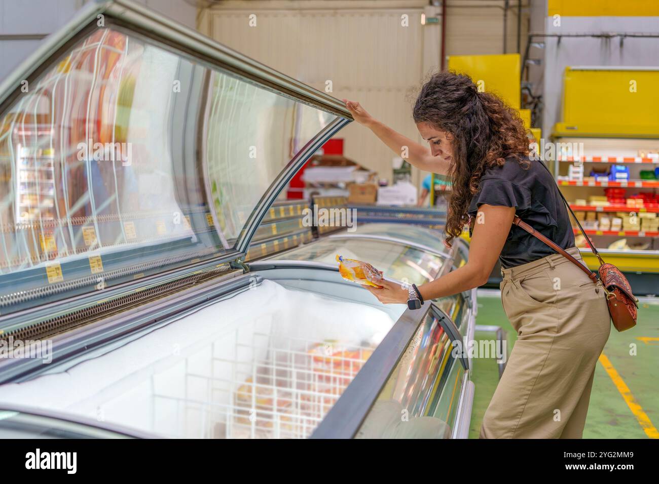 Middle-Aged Woman Selecting Frozen Foods in Supermarket's Freezer ...