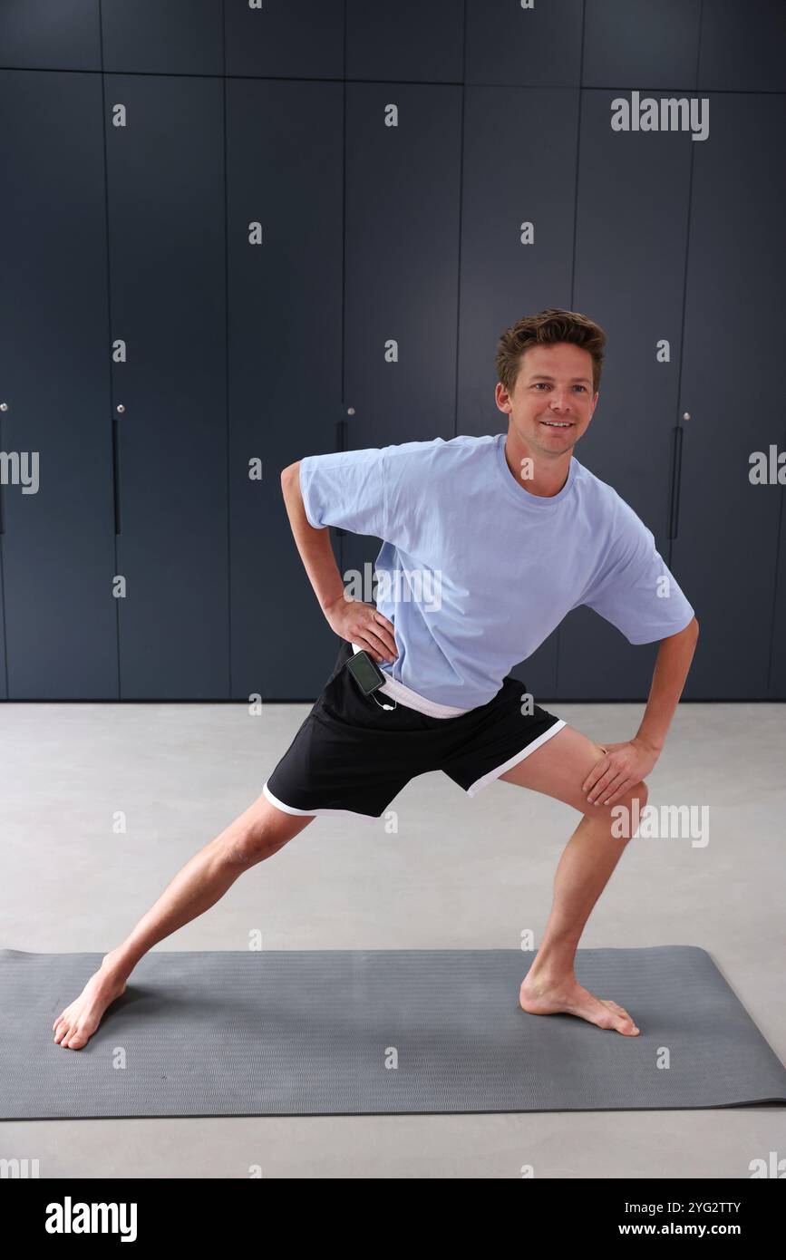 Smiling man stretching in gym Stock Photo - Alamy