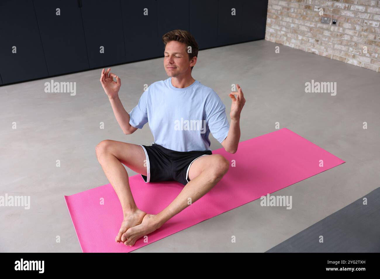 Man meditating on mat in hi-res stock photography and images - Alamy