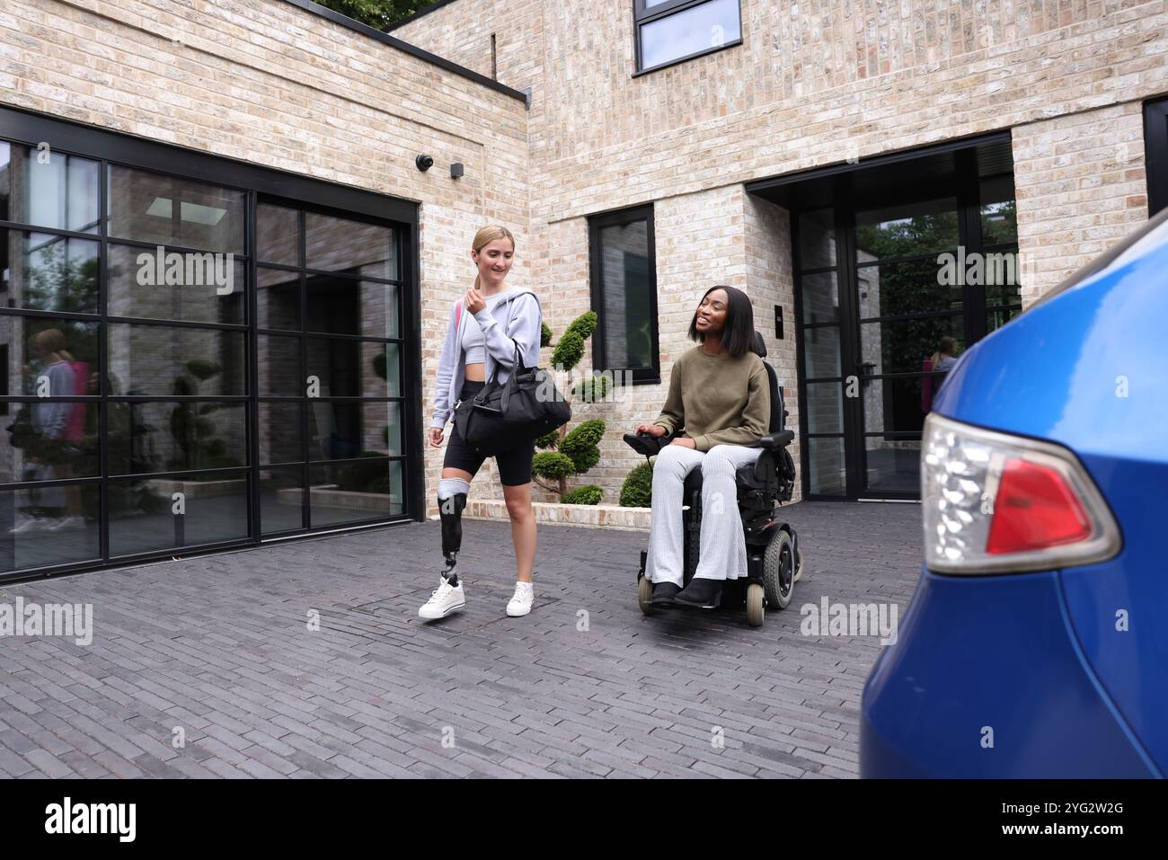 Smiling women leaving gym building together Stock Photo - Alamy