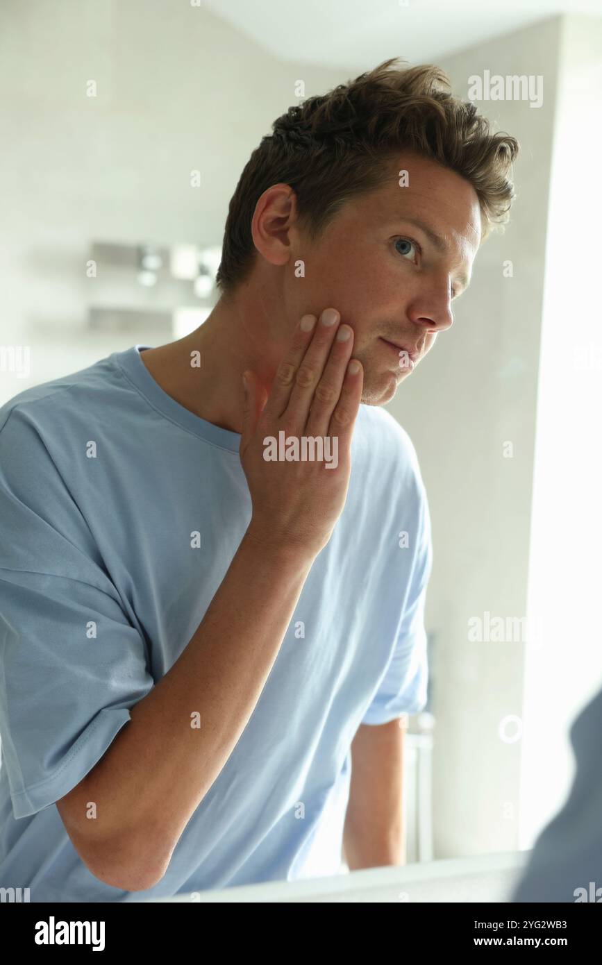 Man reflecting in bathroom mirror Stock Photo - Alamy