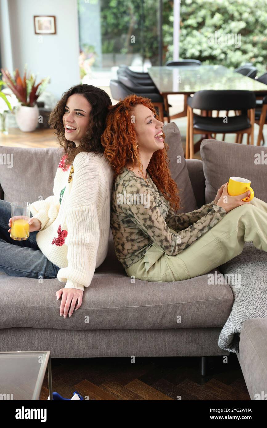 Two women sitting on sofa hi-res stock photography and images - Alamy