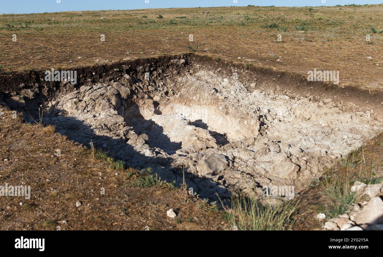 Rocky bottom of an archaeological pit dug on a hillside in search of ...