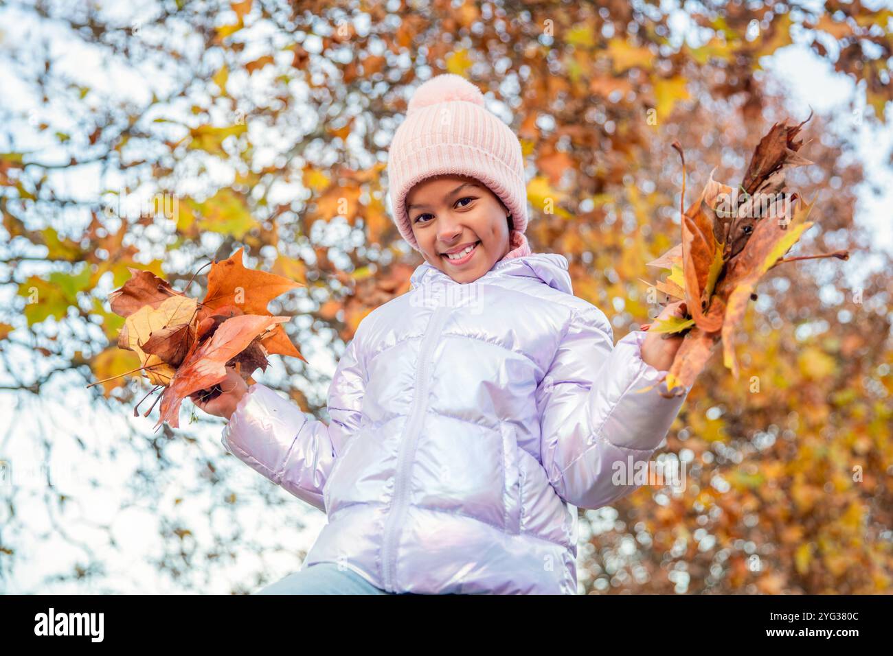 Happy little black girl playing in autumn park on warm sunny fall day ...