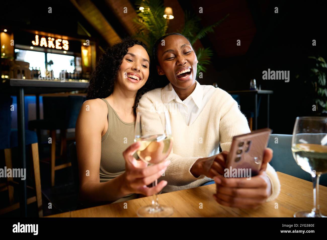 Two friends talking taking photos hi-res stock photography and images ...