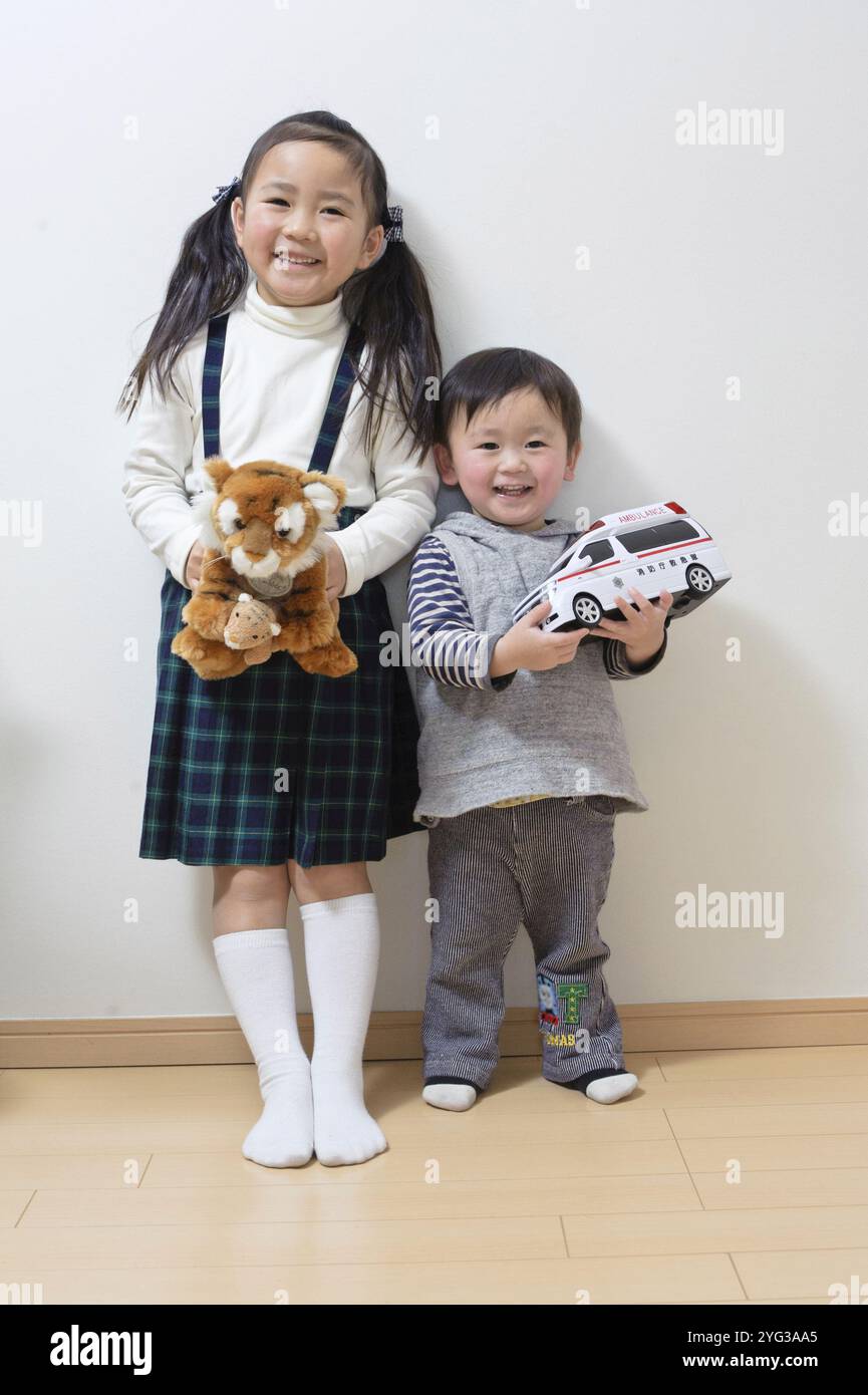 Sister and brother get on well with each other holding a toy and ...