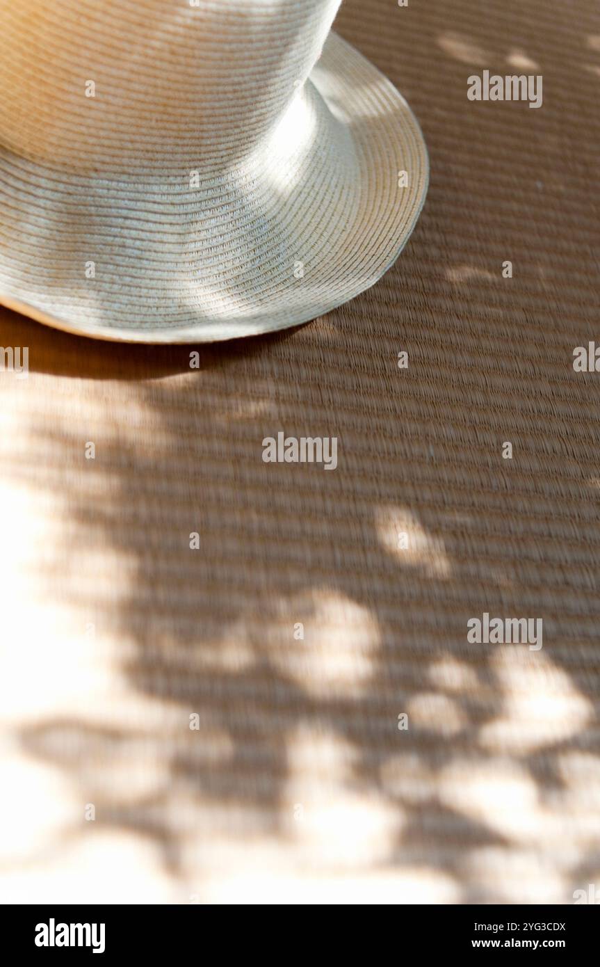 Shadow of tree falling on straw hat Stock Photo - Alamy