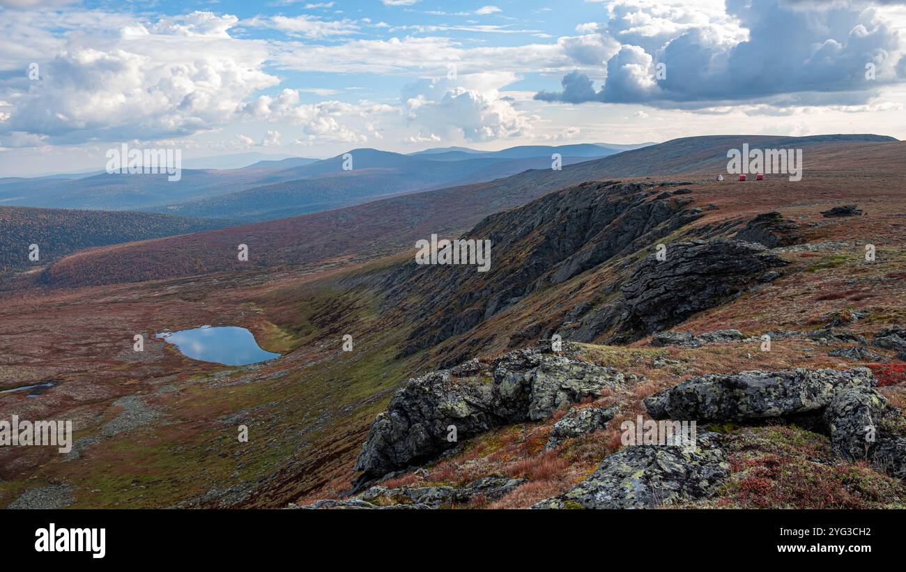 Colorful autumn tundra stretches across rolling hills and rocky cliffs ...