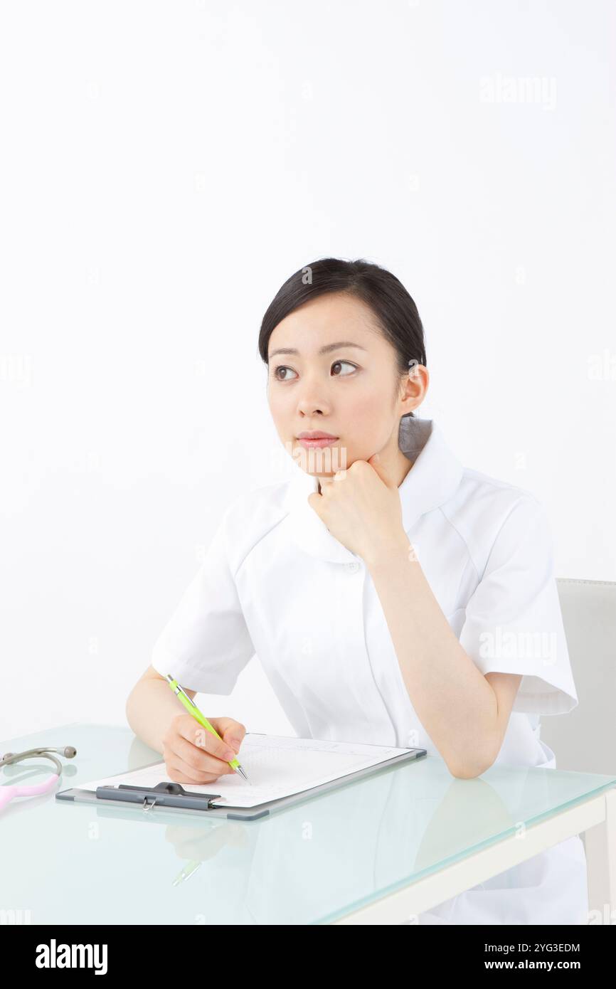 Nurse thinking at desk Stock Photo - Alamy