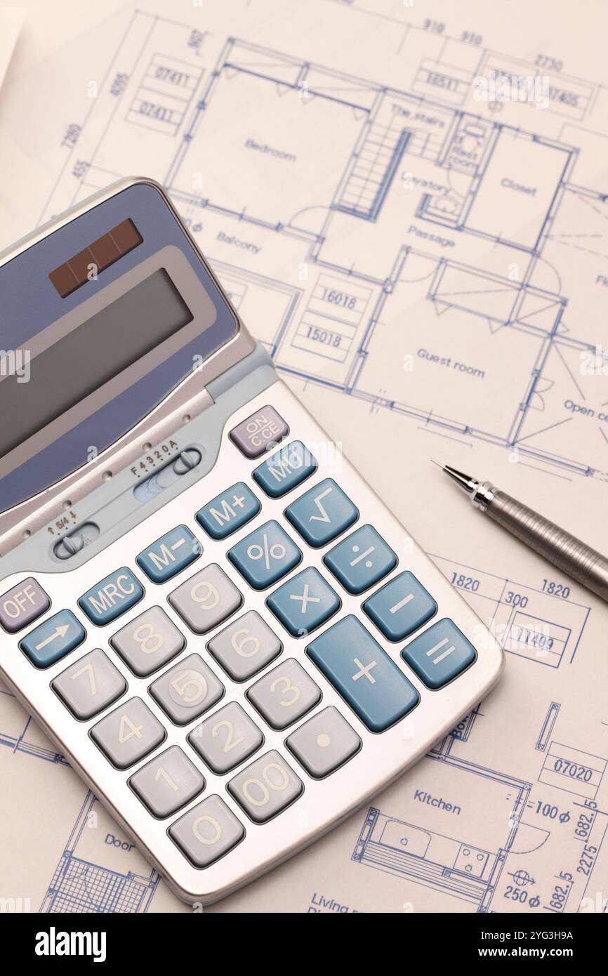 Blueprints, calculator and pen Stock Photo - Alamy