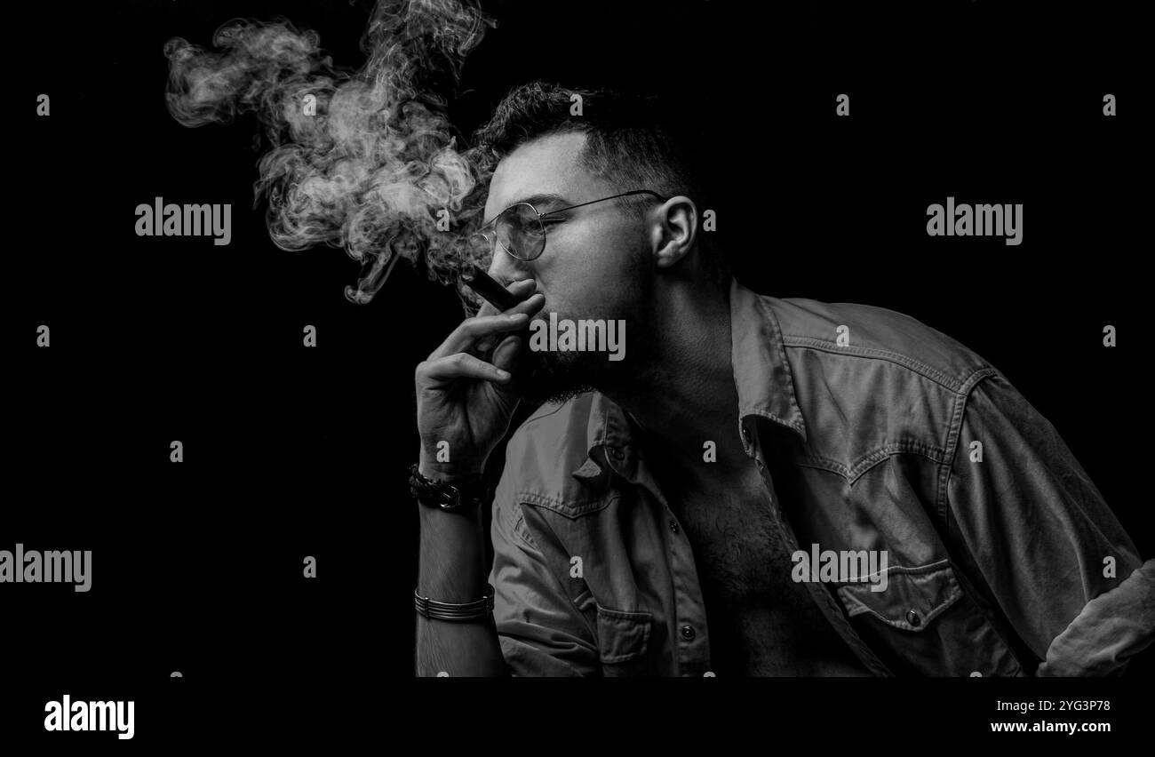 Man in glasses and smoking cigar against black background. Smoke ...