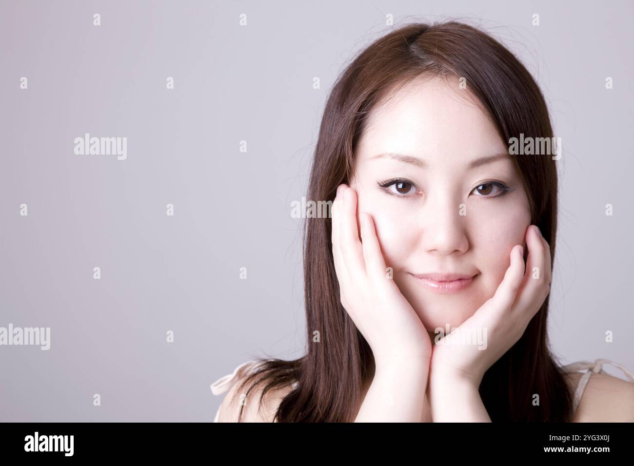 Woman with both hands on cheeks Stock Photo - Alamy