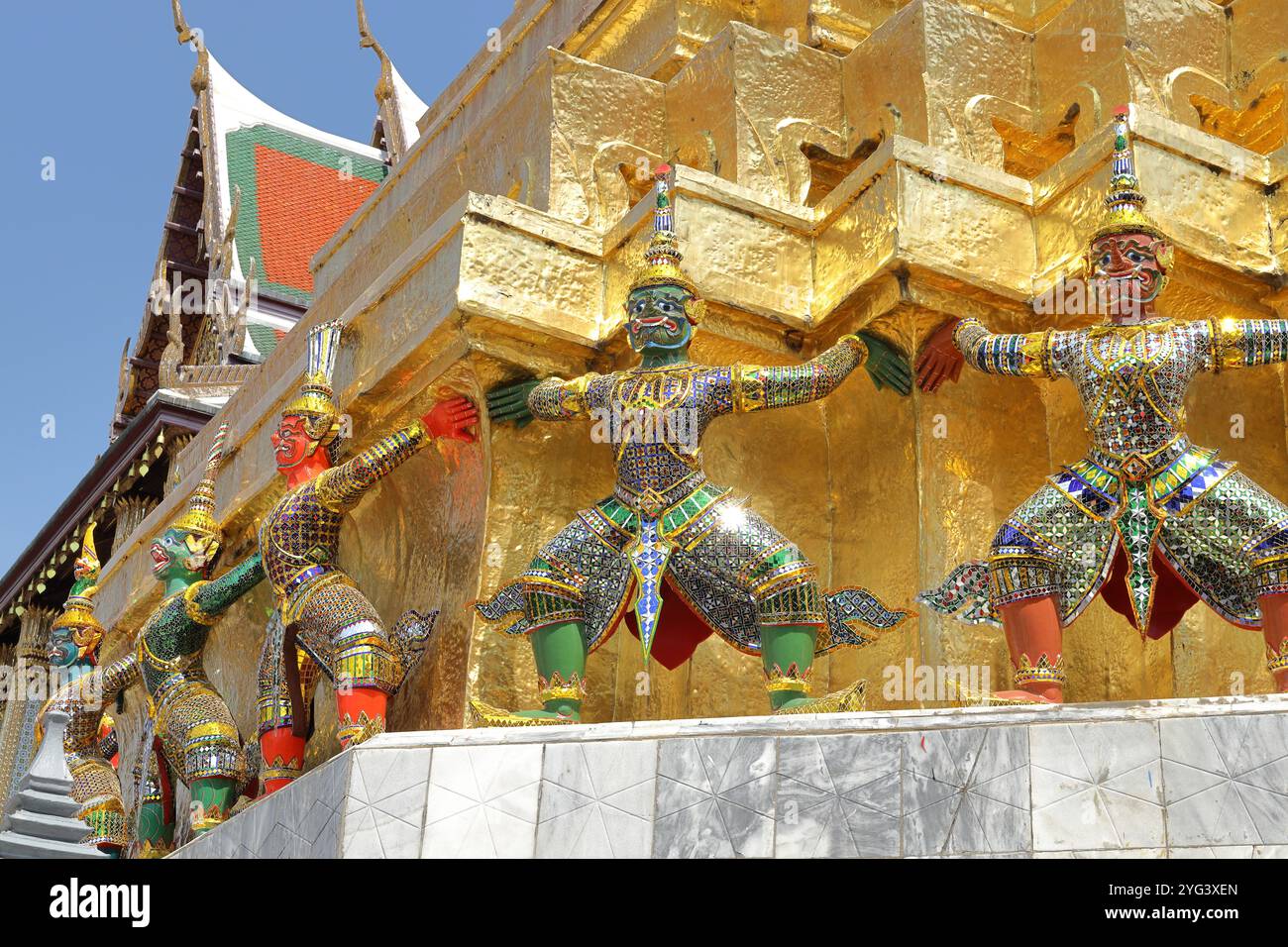Bangkok, Thailand - Yaksha mythical demons supporting a golden chedi or ...
