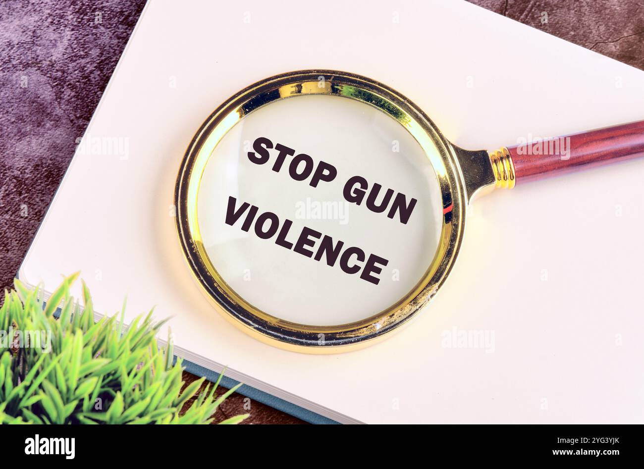 STOP GUN VIOLENCE text written in a notebook through a magnifying glass ...