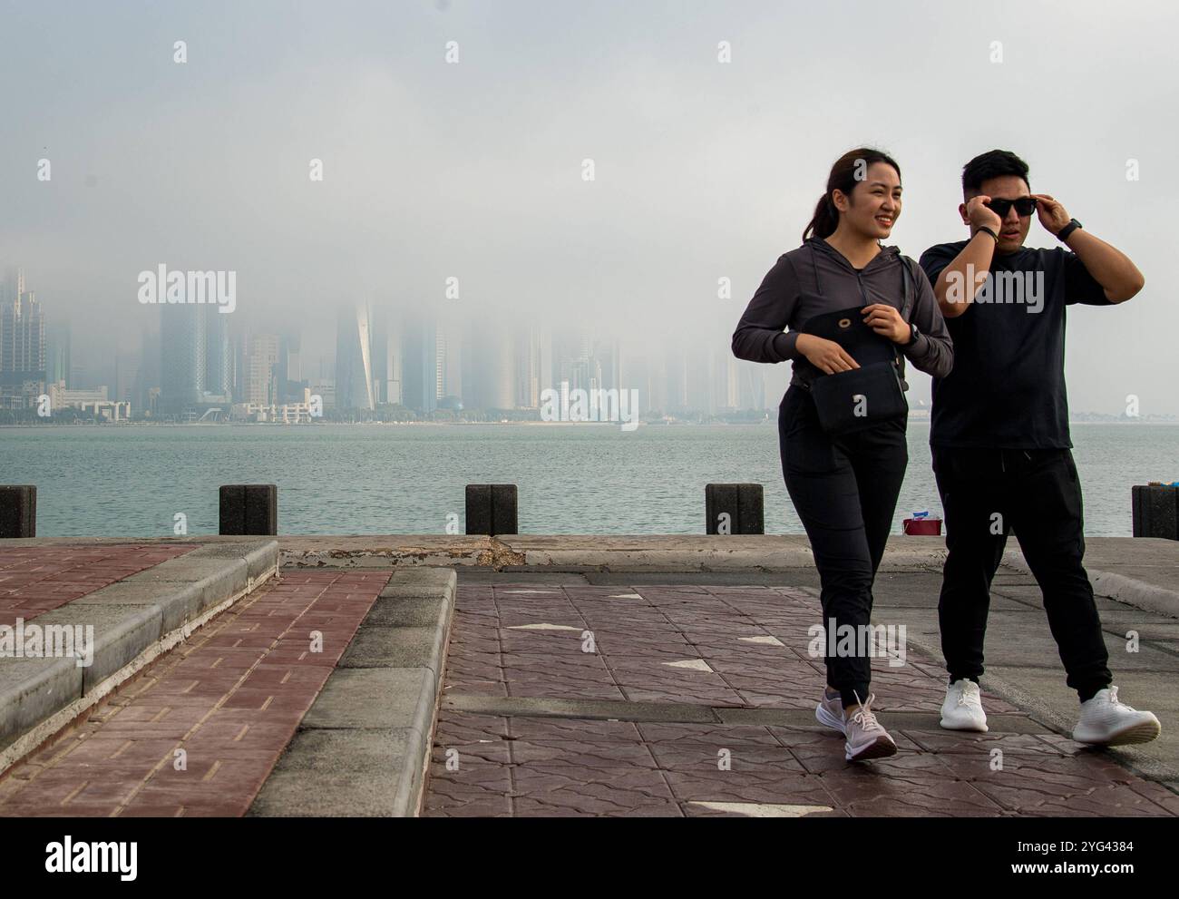 Foggy day in Doha People walk along the Doha Corniche in heavy fog on ...