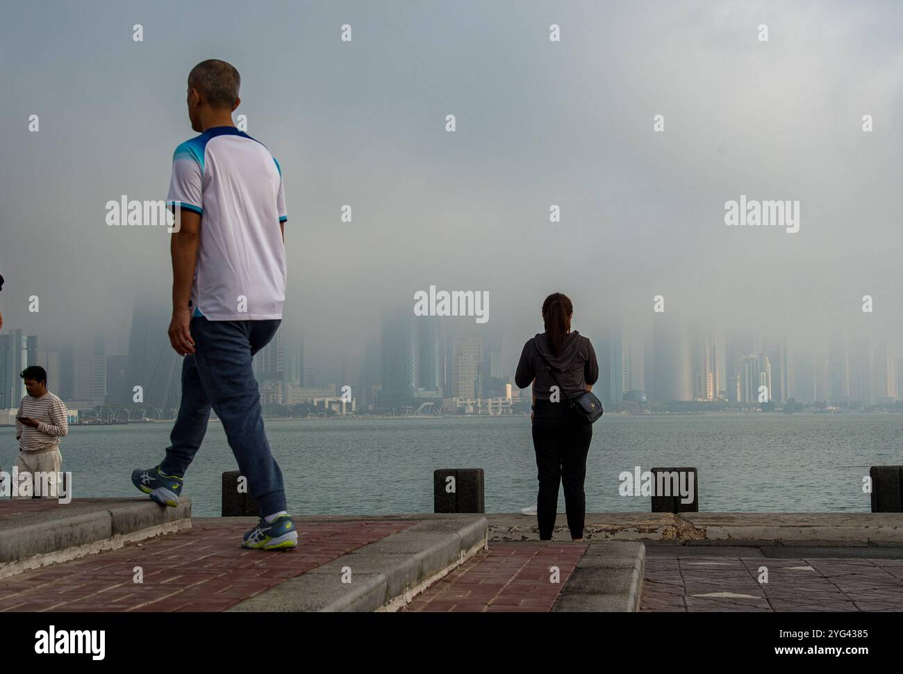 Foggy day in Doha People walk along the Doha Corniche in heavy fog on ...