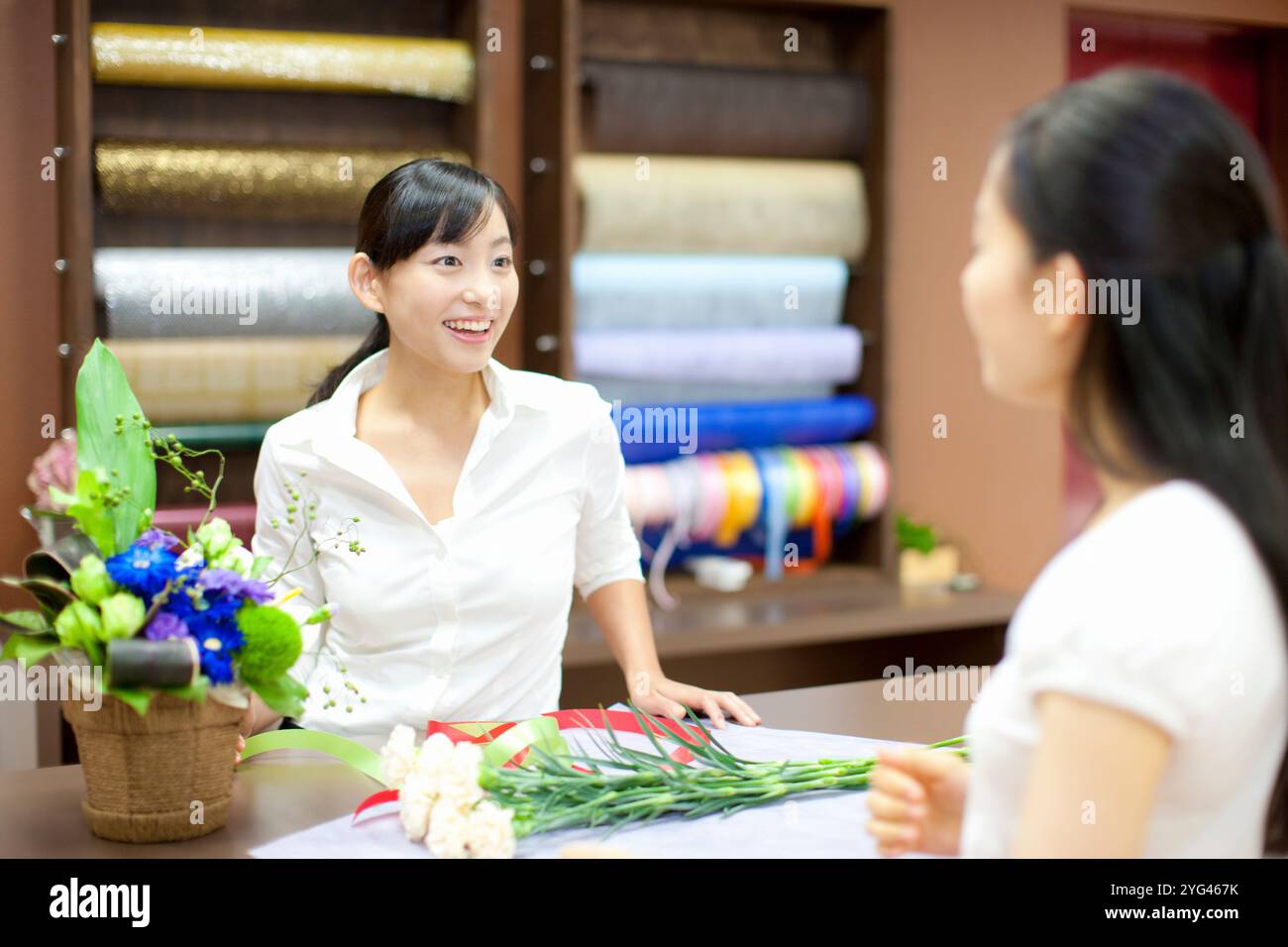 Female florist shop assistant and customer Stock Photo - Alamy