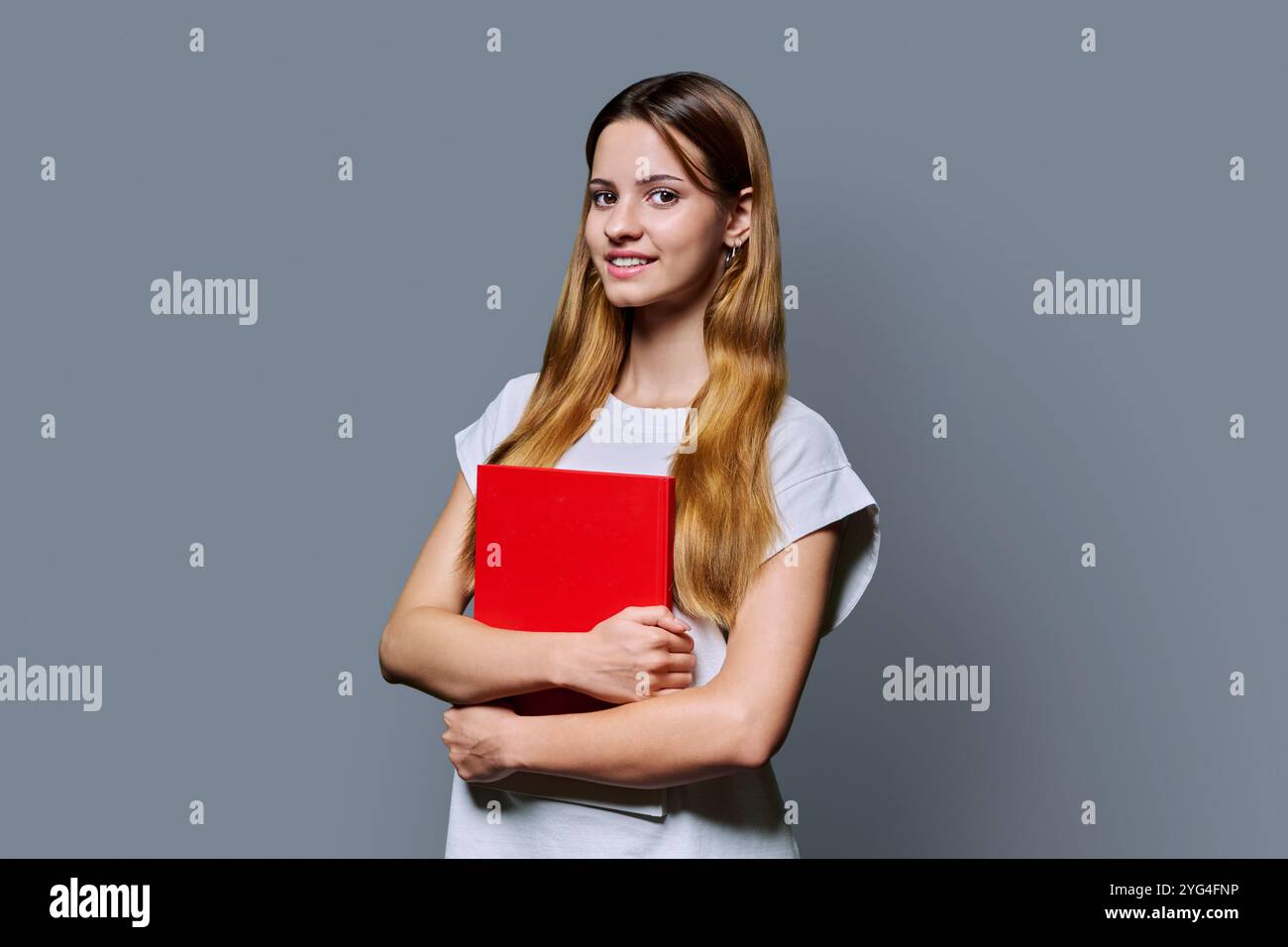 Portrait of teenager student girl holding notebook looking at camera on ...