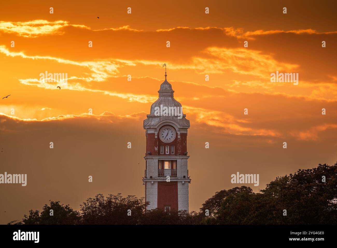 Historic City Clock Tower of Railway Station at Sunset with Dramatic Sky and Birds. Panorama ...