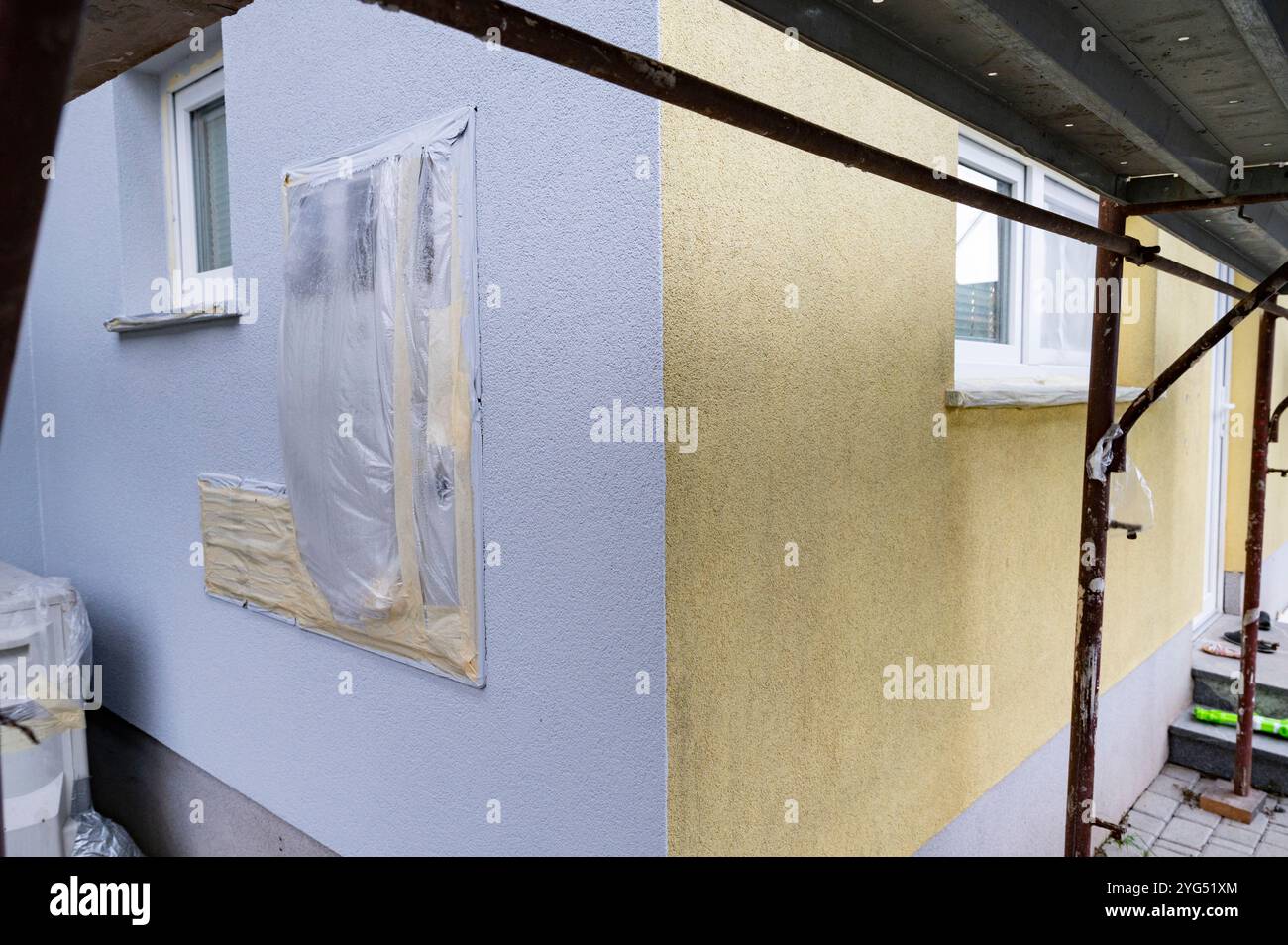 A house exterior with two contrasting paint colors, blue and yellow, in ...