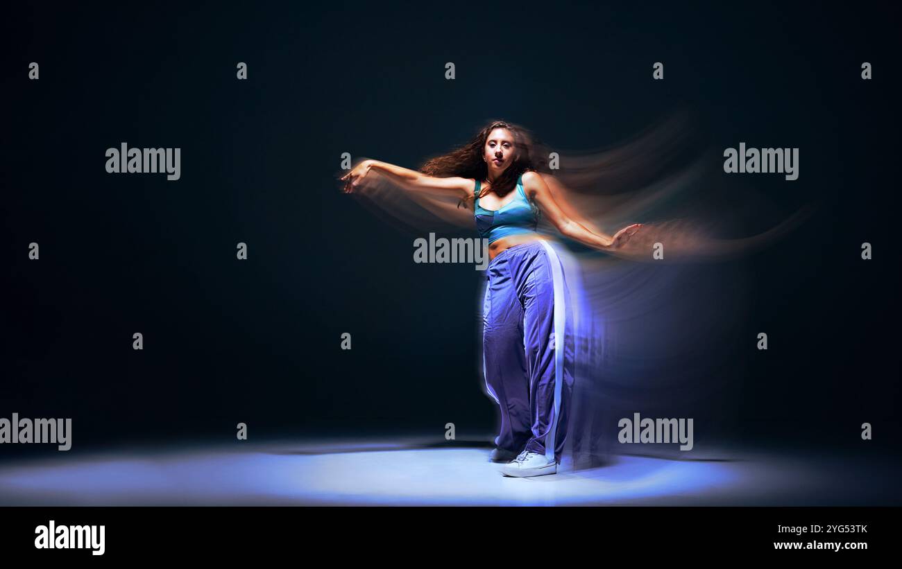Creative design. Young women in sport style clothes in motion, dancing ...
