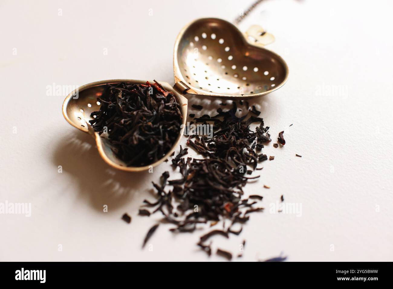 tea leaves inside of stainless steel tea bag and some of it scatter ...