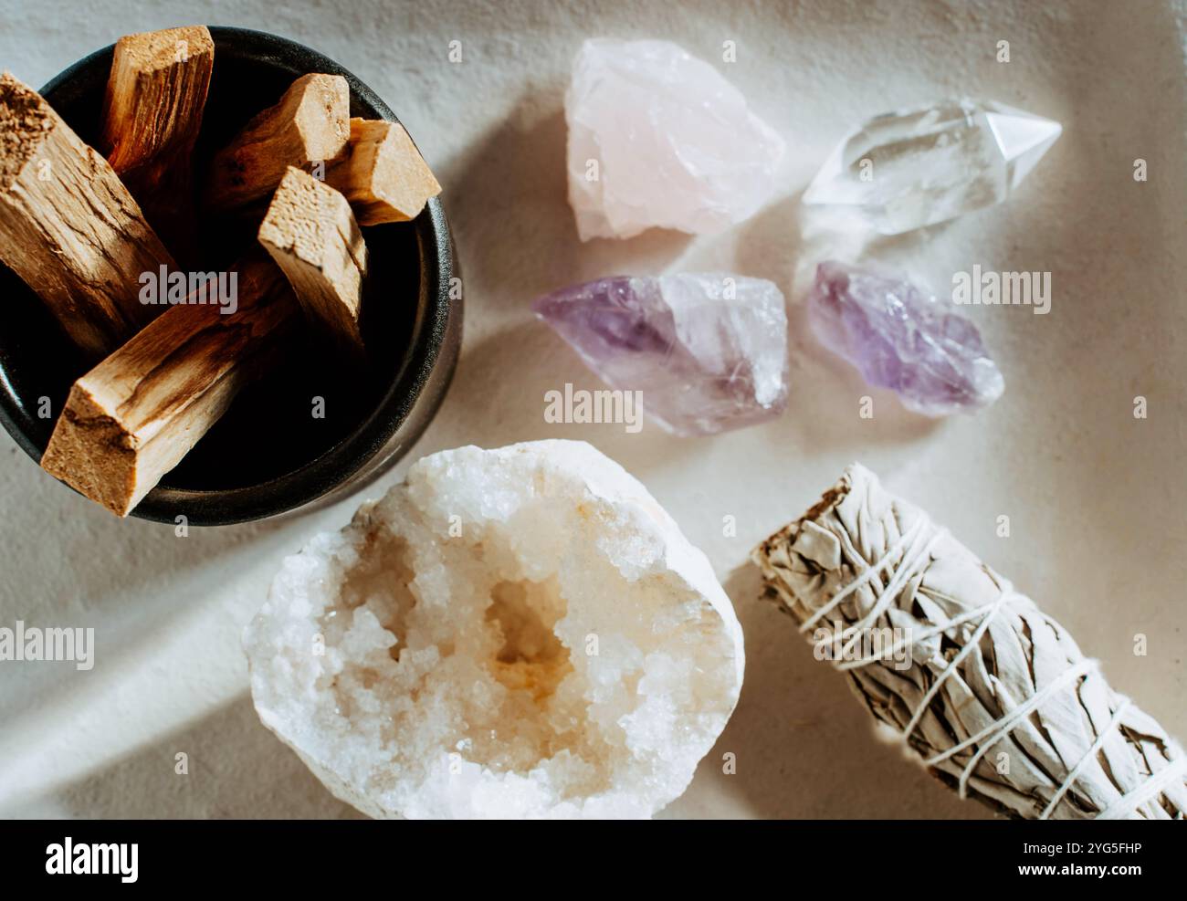 White sage and Palo Santo and amethyst and quartz crystals on a light ...