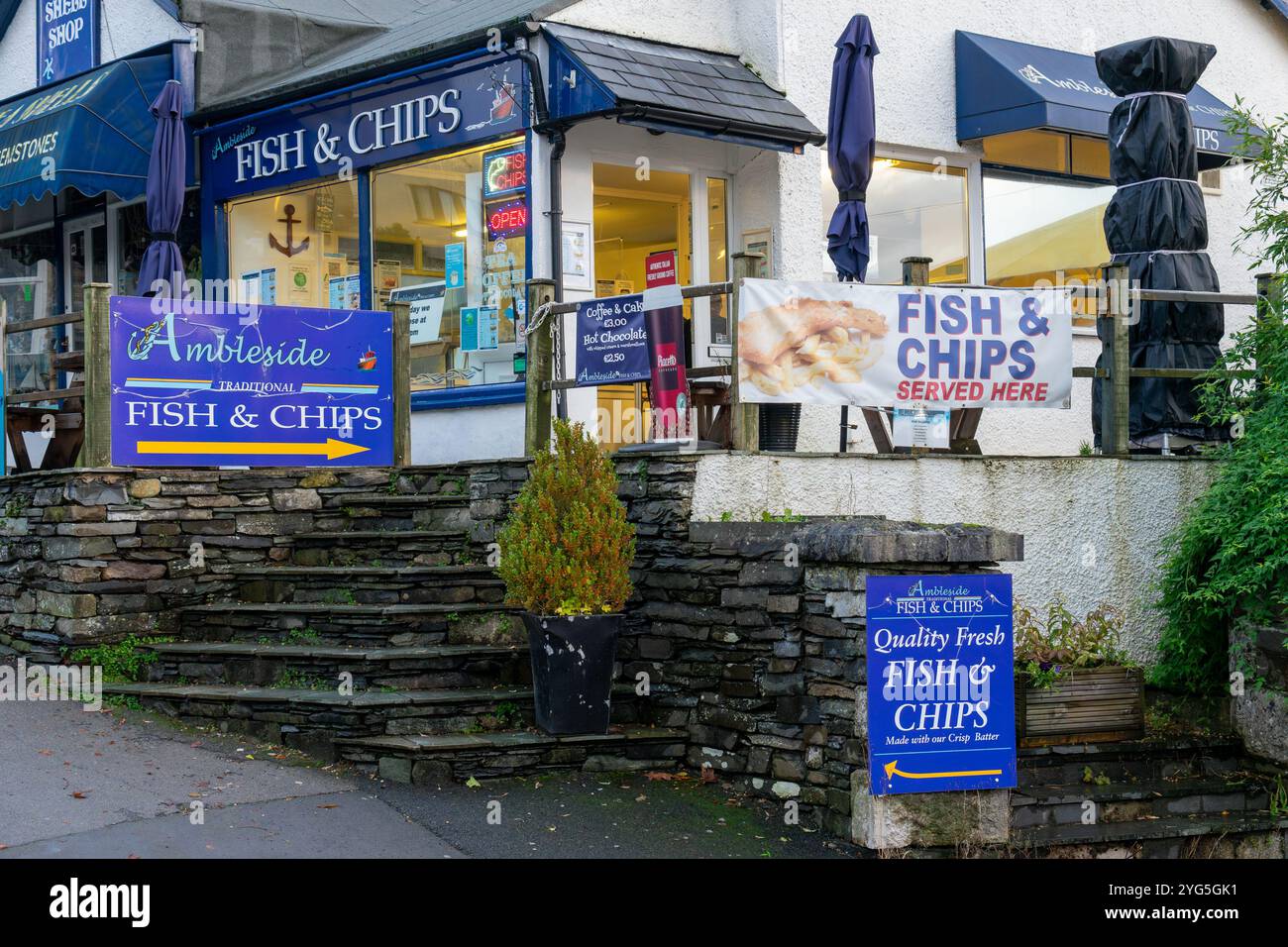 Fish and chip takeaway shop with many blue painted signs outside on a ...