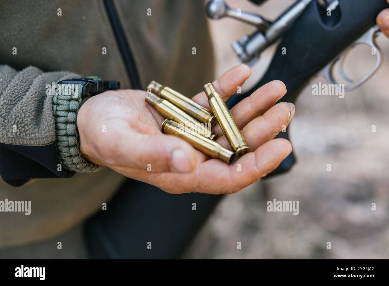 Hunter holding rifle cartridges close up Stock Photo - Alamy