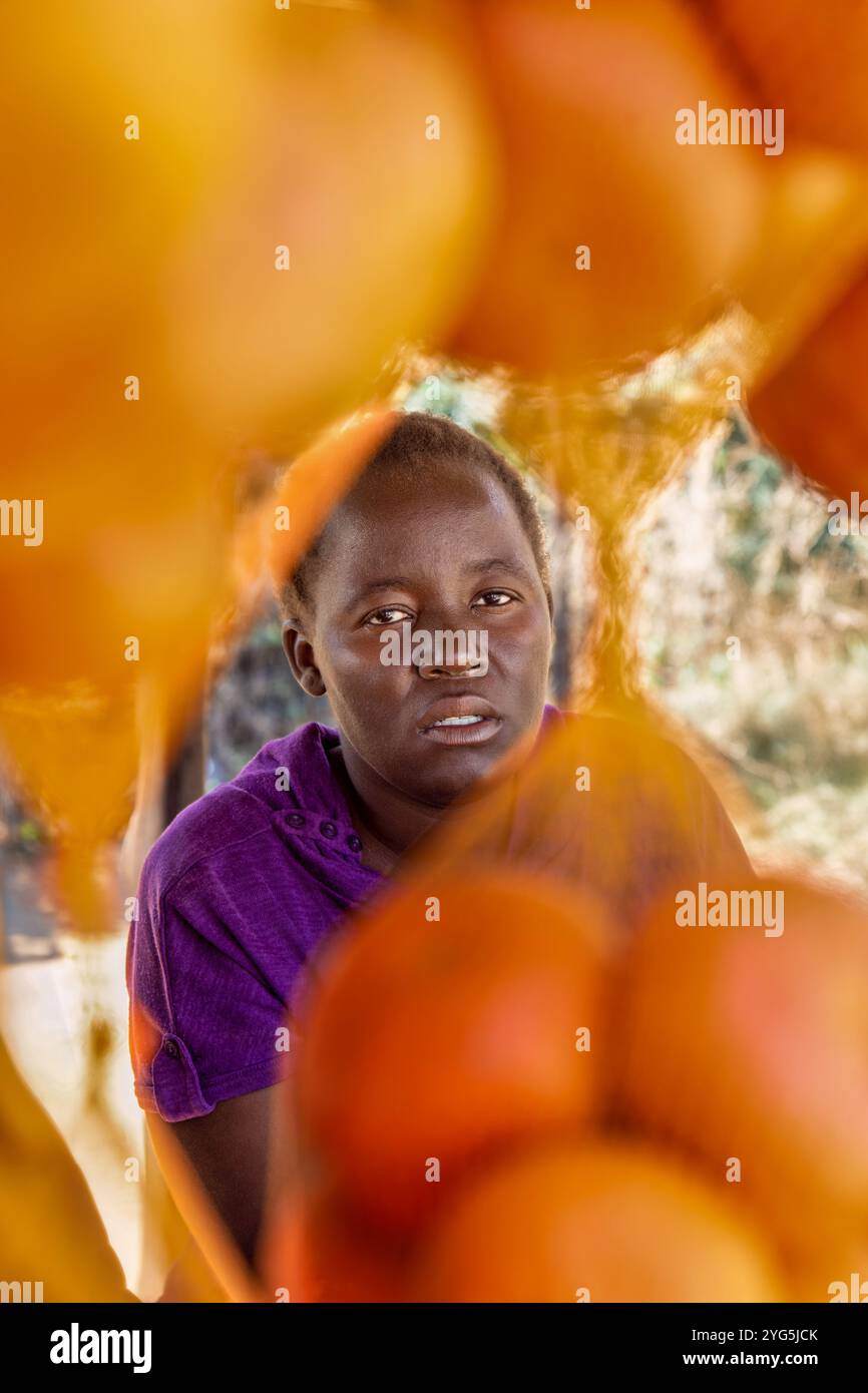 portrait of village African woman, hawker street vendor of fruits, bags ...