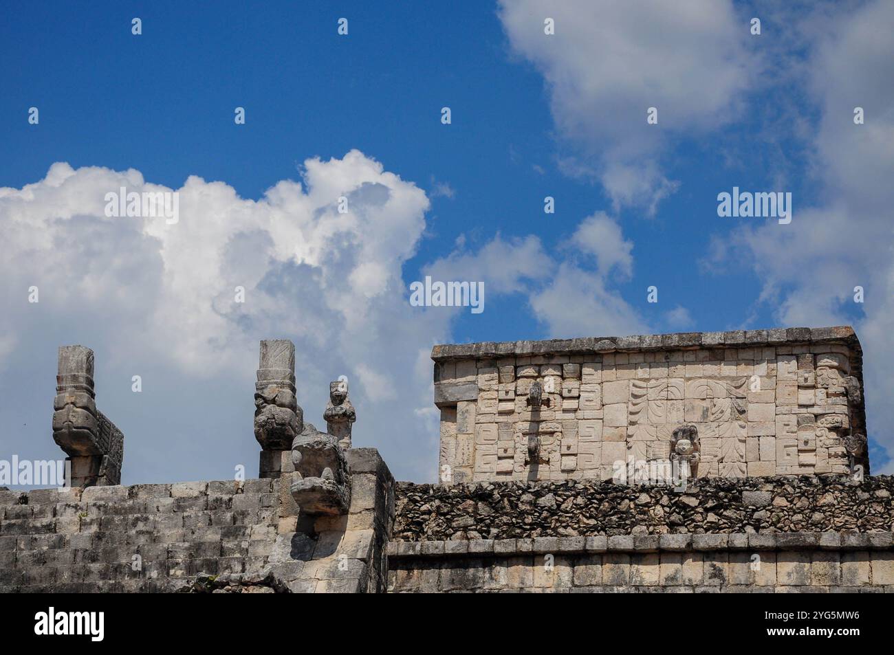 Ancient stone structures of Chichen Itza under a vibrant sky with ...