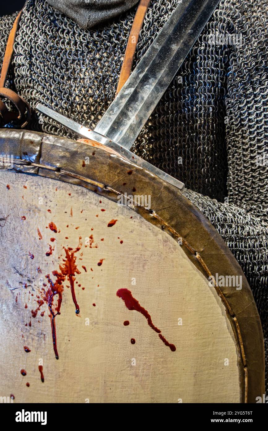 Medieval warrior in iron shirt holding sword and bloody shield Stock ...