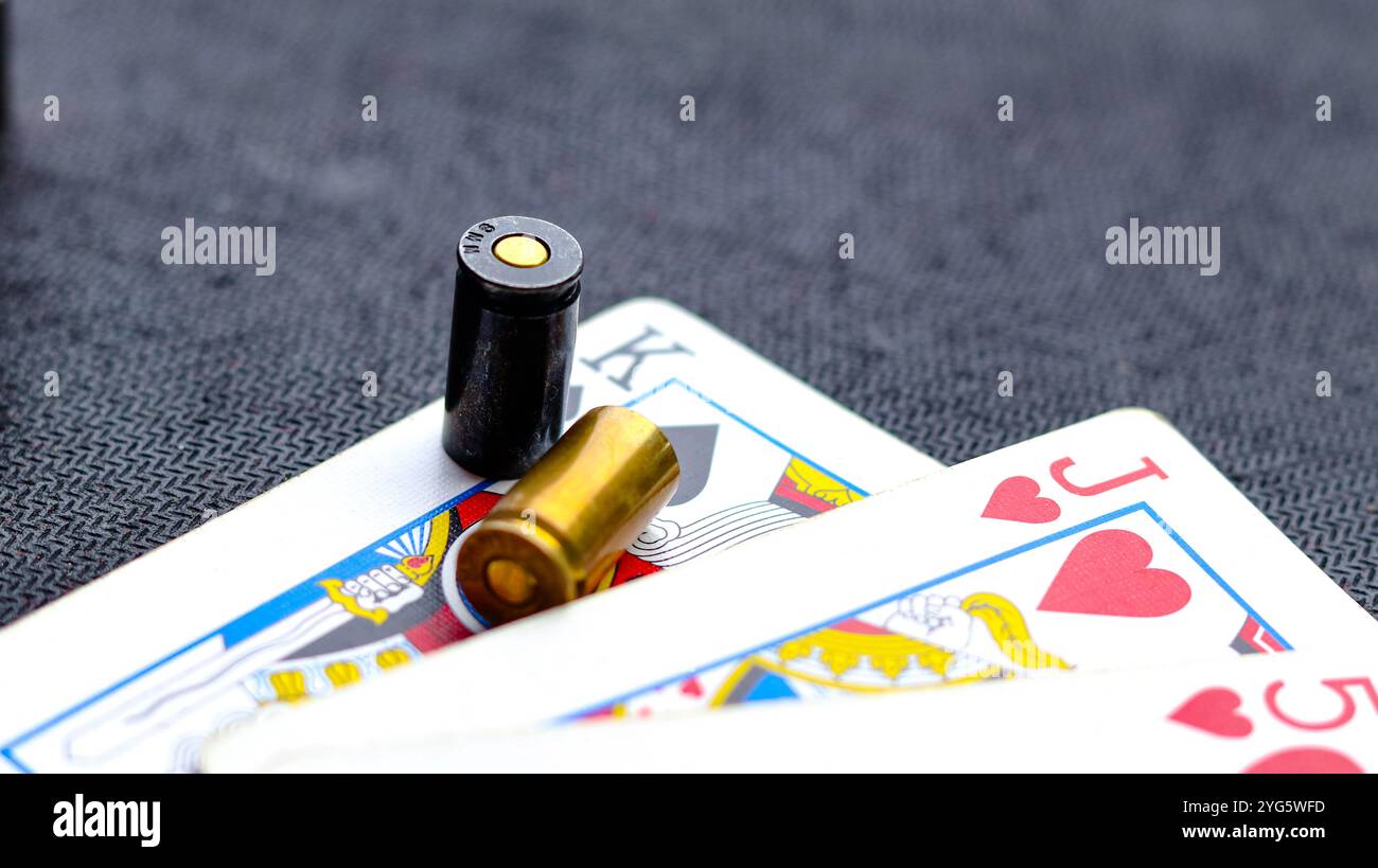 Empty bullet casings on a play card background, with playing cards ...