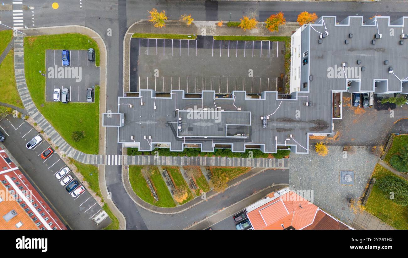 Aerial view of a parking lot adjacent to a modern building with a ...