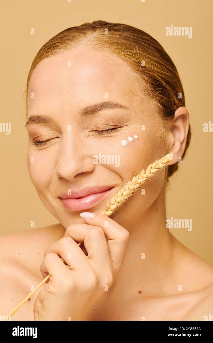 This young woman with radiant skin gently holds wheat while embracing a ...