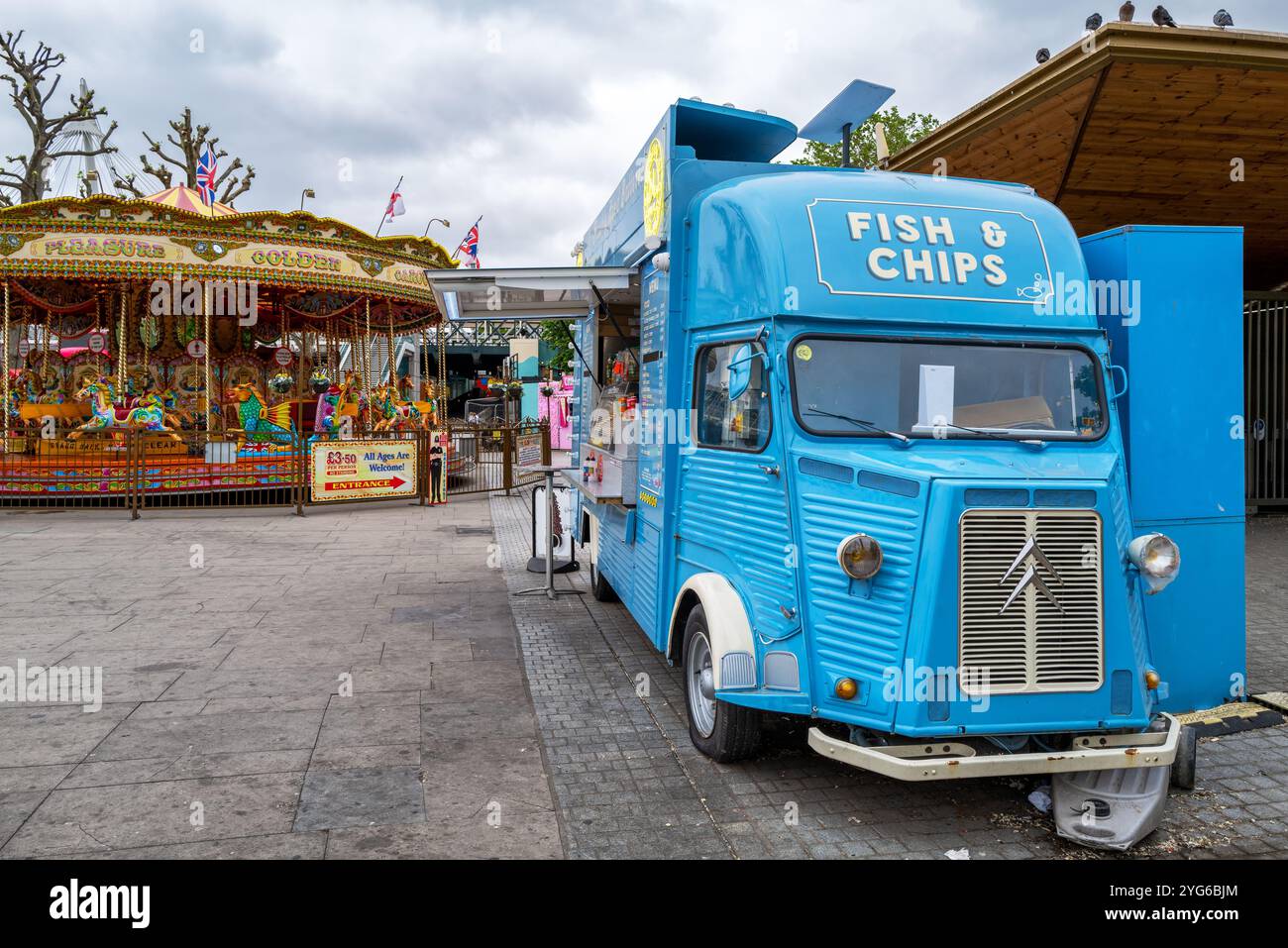 London, UK - 6 June 2023: A fish and chip van and carousel on the ...