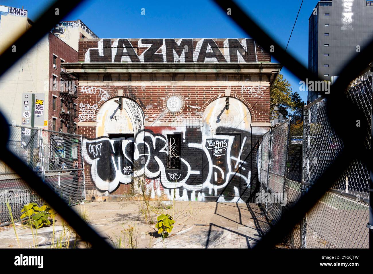 Vibrant street art mural Jazman on a city building seen through a chain ...