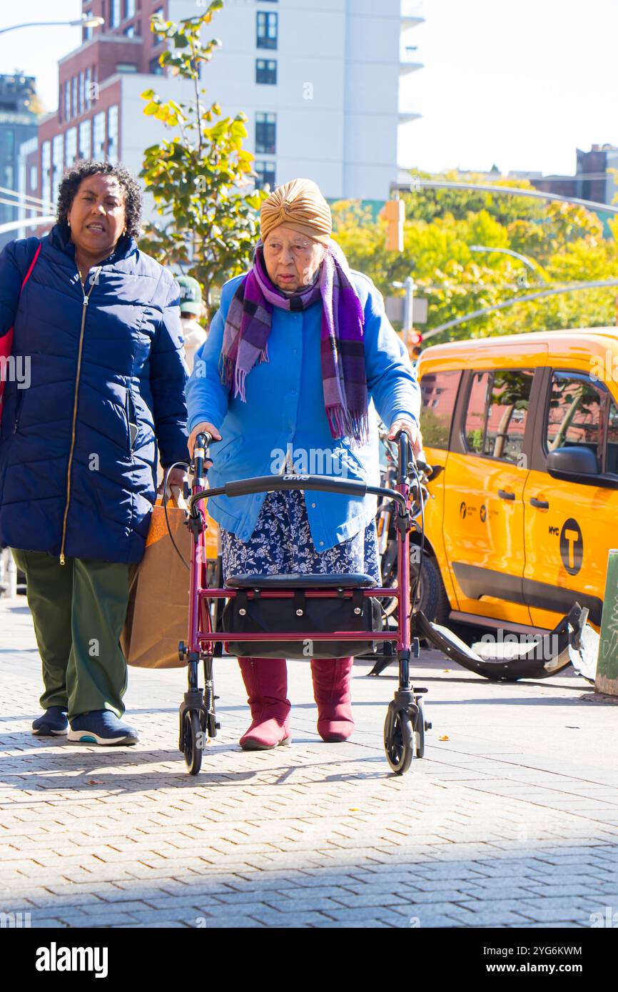 elderly asian woman in chinatown lower east side walks with walker or ...