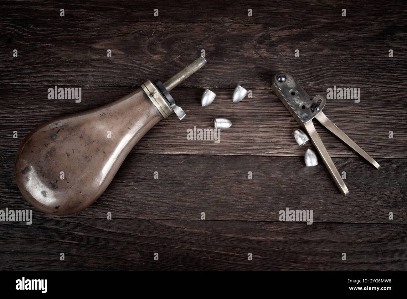 old west bullet mold with bullets and powder flask on wood deck ...