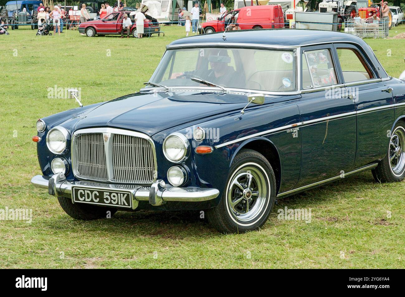 A 1962 blue Rover 3.5 litre P5B saloon car drives at a country fair in ...